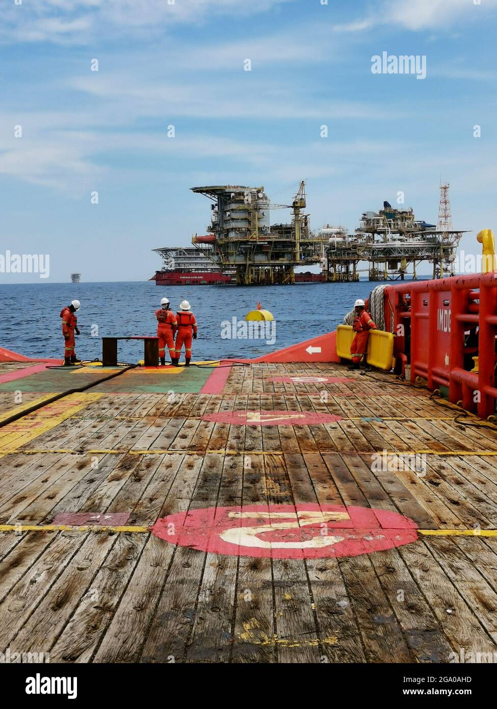 marine crew working on deck during anchor handling operation near oil ...