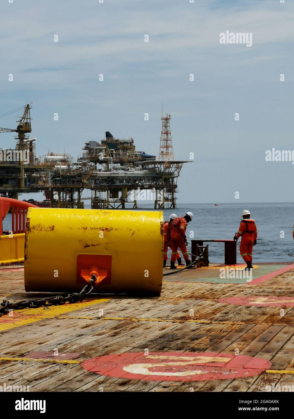 Marine crew working on deck during anchor handling operation near hi ...