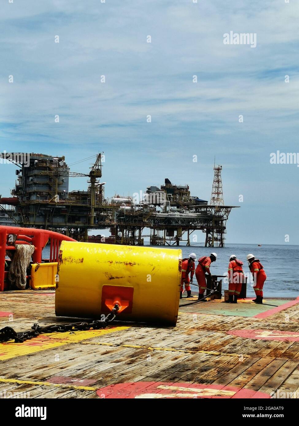 marine crew working on deck during anchor handling operation near oil ...