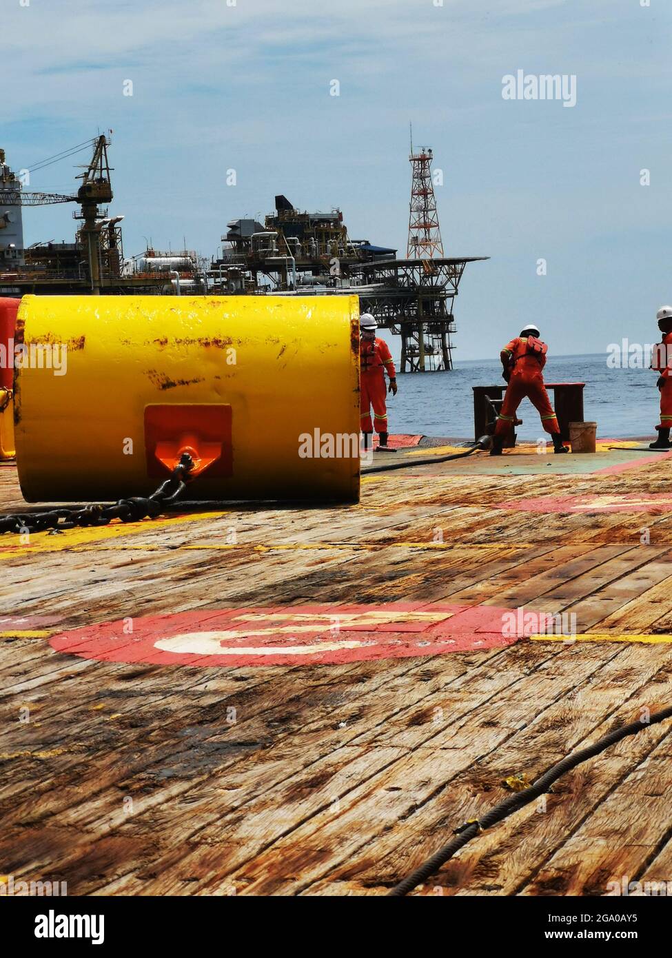 marine crew working on deck during anchor handling operation near oil ...