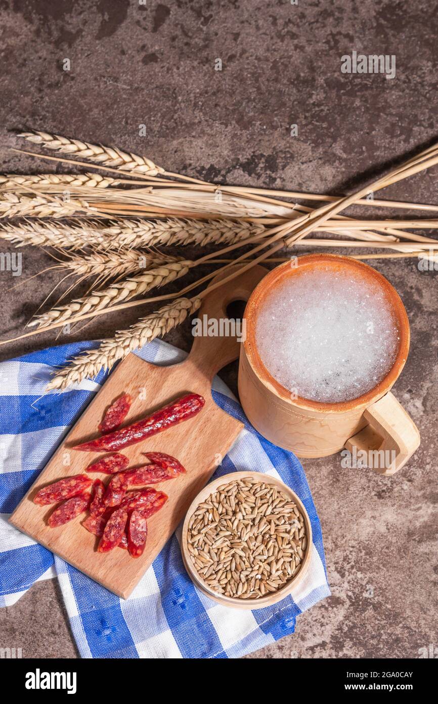 Oktoberfest concept. Beer and grain, sausages, wooden mugs. A trendy ...