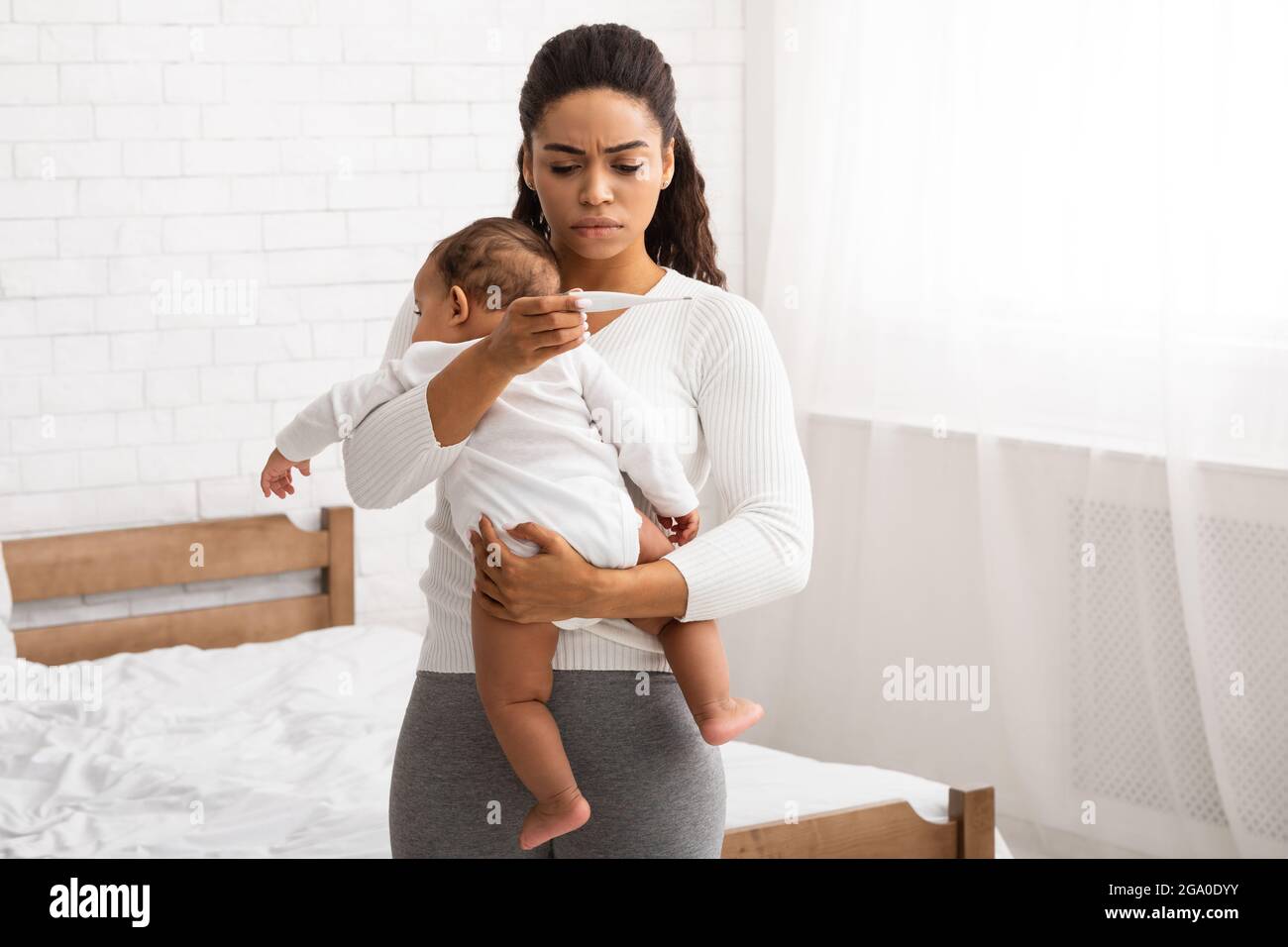 African American Mon Carrying Sick Infant Son Having Fever Indoor Stock ...