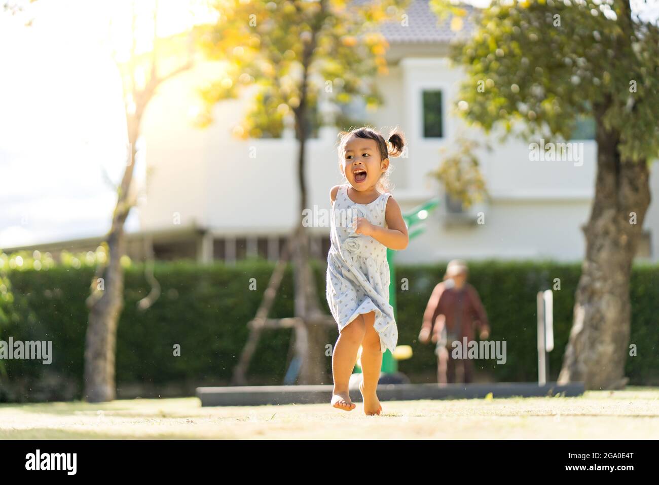 Southeast Asian female kid runs around the playground Stock Photo - Alamy