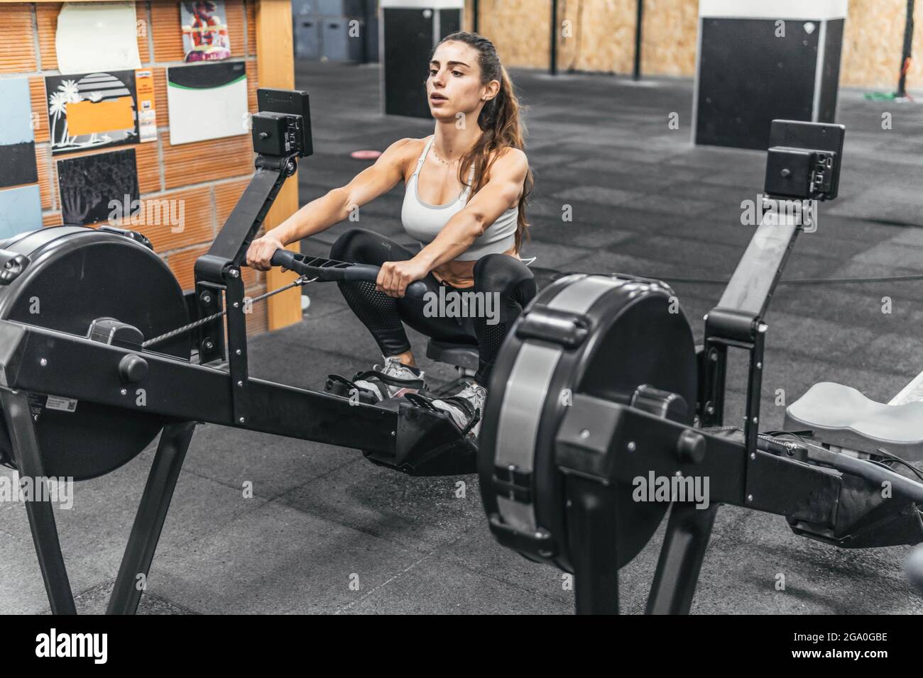 woman on her back doing rowing in the gym, crossfit Stock Photo - Alamy