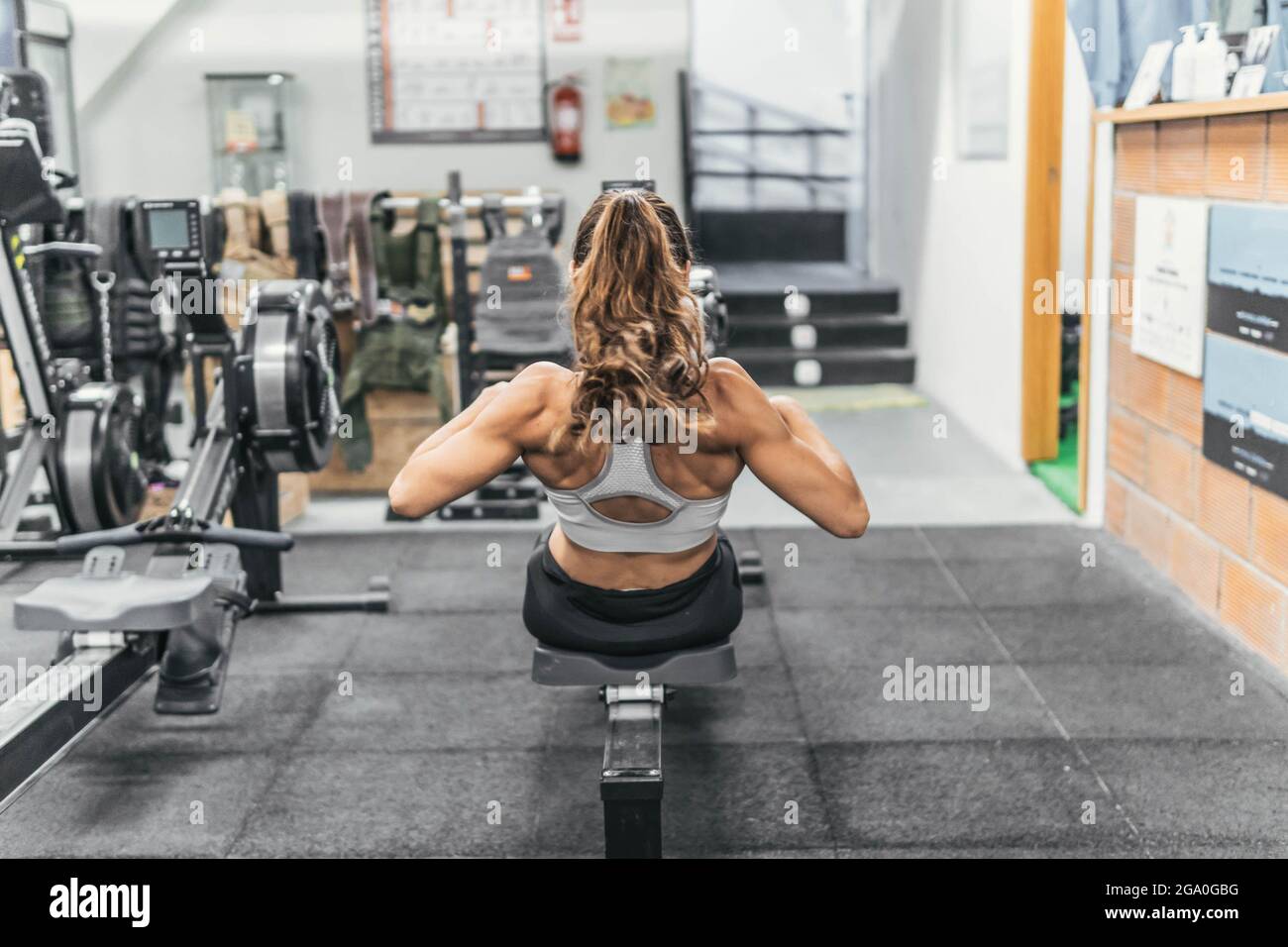 woman on her back doing rowing in the gym, crossfit Stock Photo - Alamy