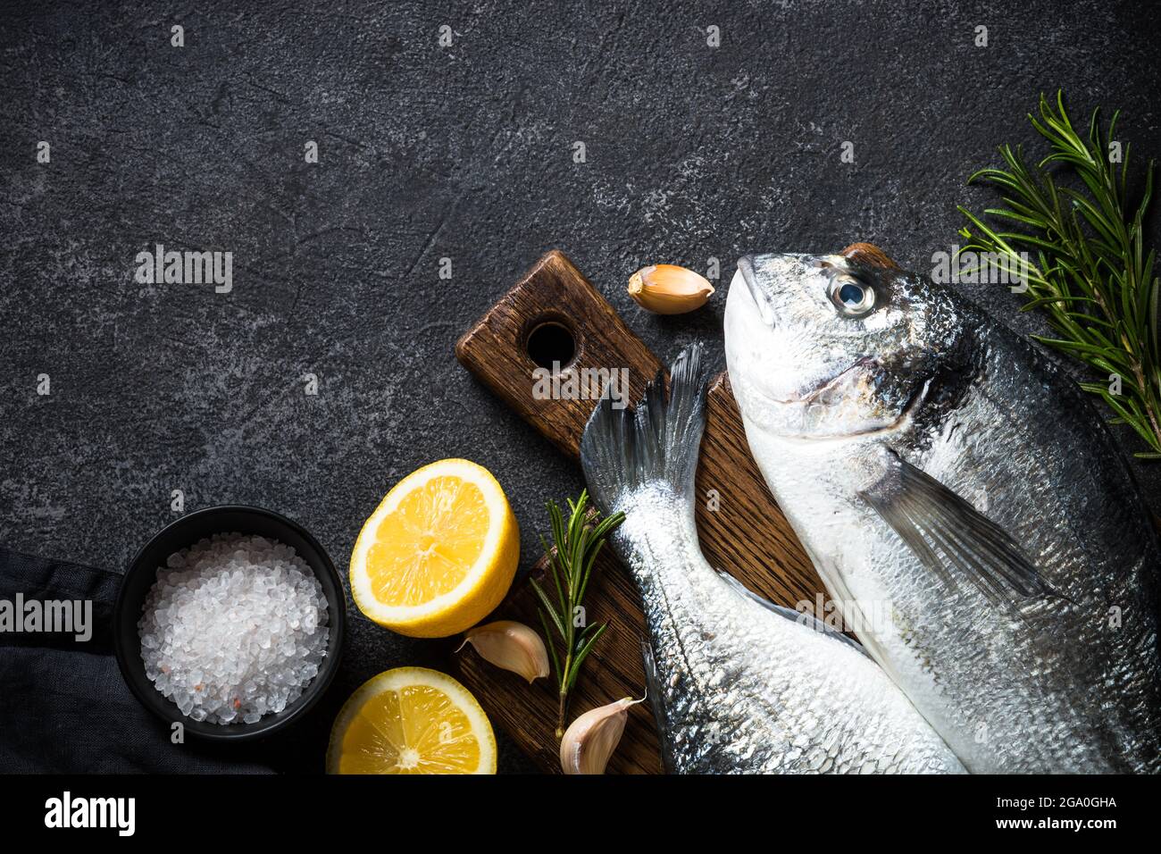 Fresh fish dorado on black stone table Stock Photo - Alamy