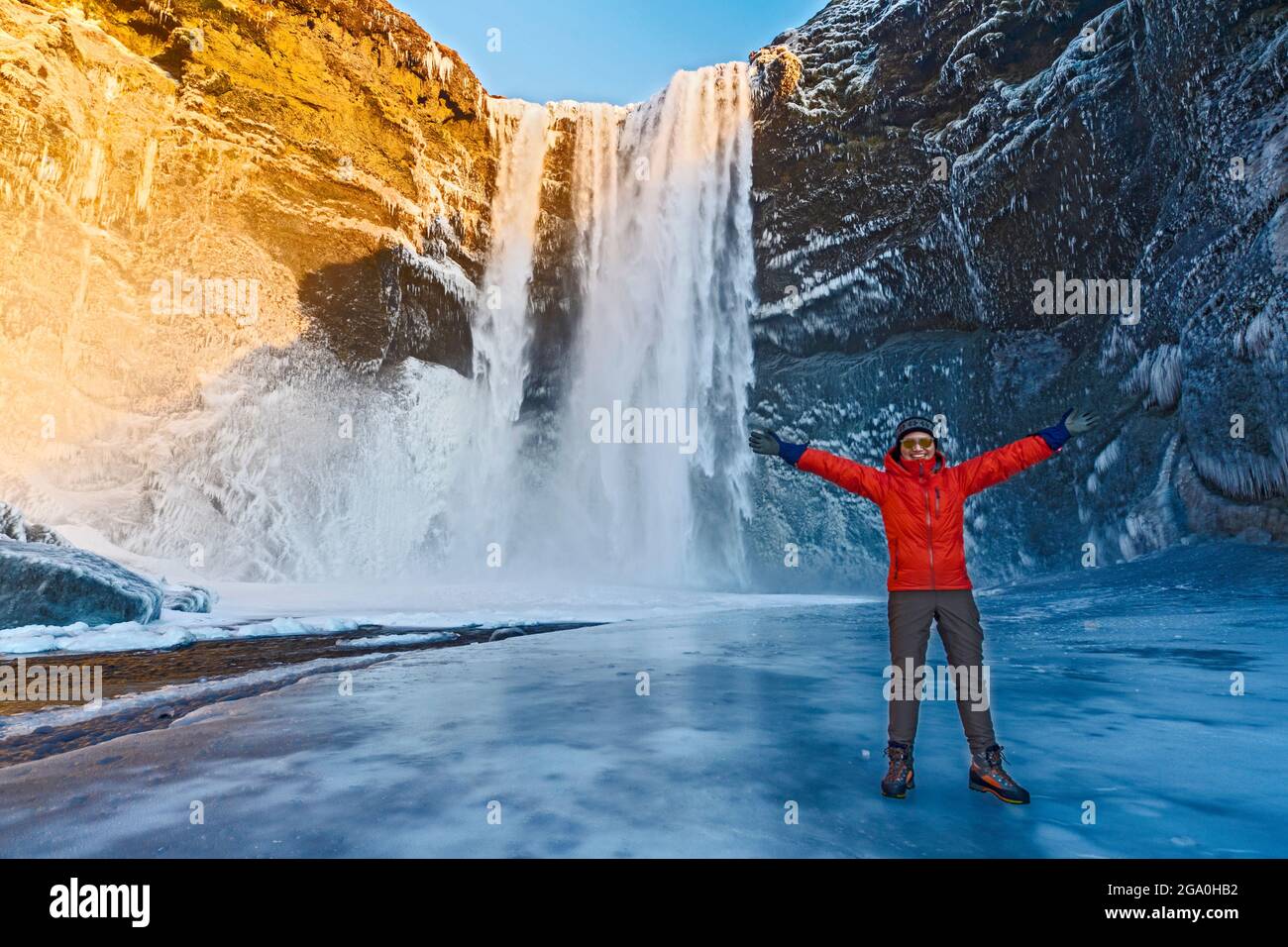 woman posing with stretched out arms in front of waterfall Stock Photo ...