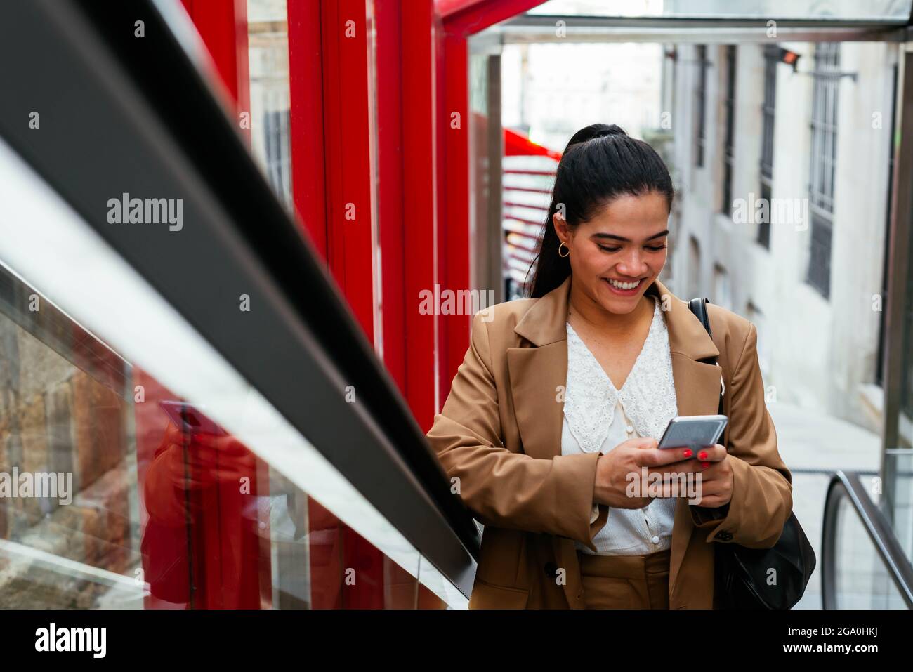 business woman checking her cellphone on an escalator Stock Photo - Alamy