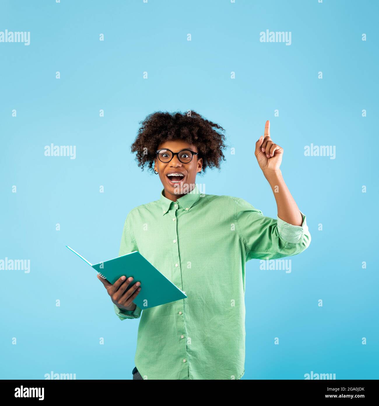 Inspiration or eureka moment. Happy black male teen student pointing ...