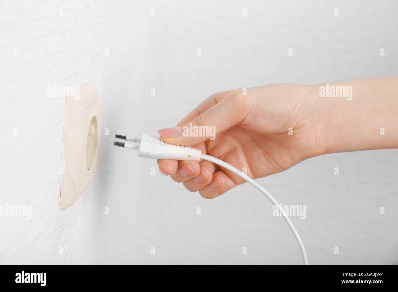Hand putting plug in electricity socket close up Stock Photo - Alamy