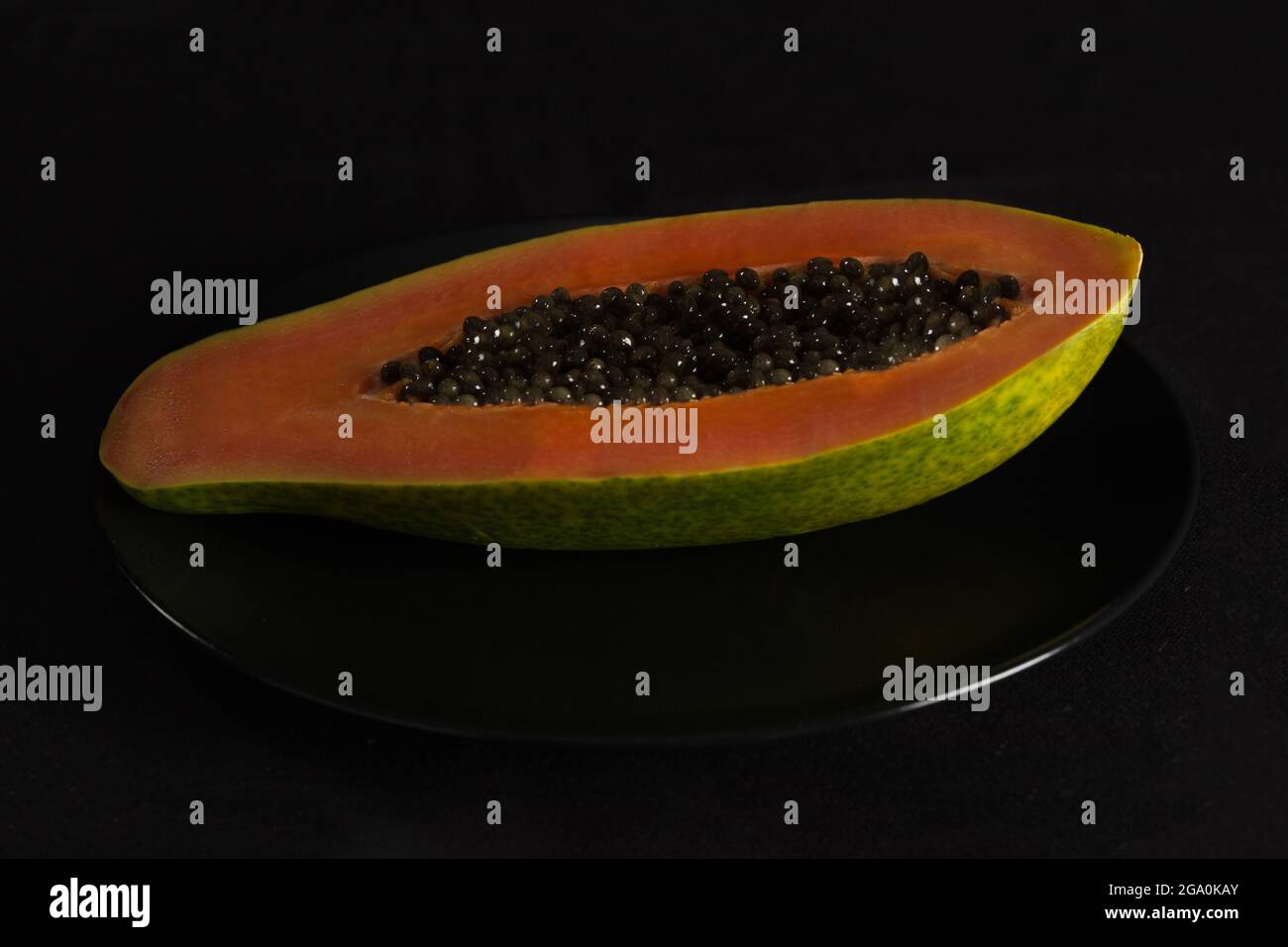 split papaya on black background Stock Photo - Alamy