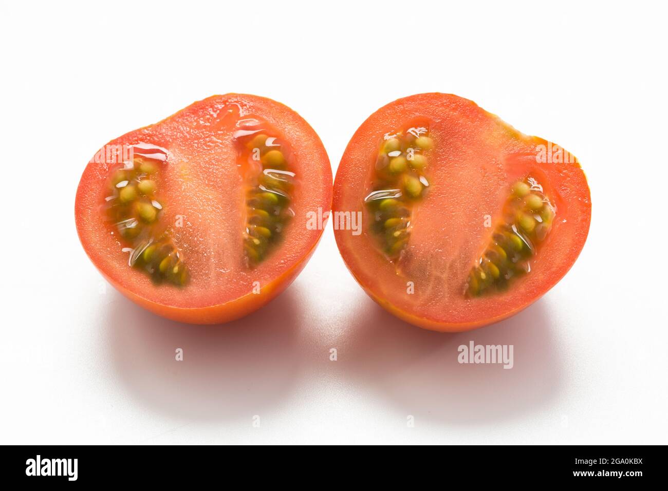 split cherry tomato on white background Stock Photo - Alamy