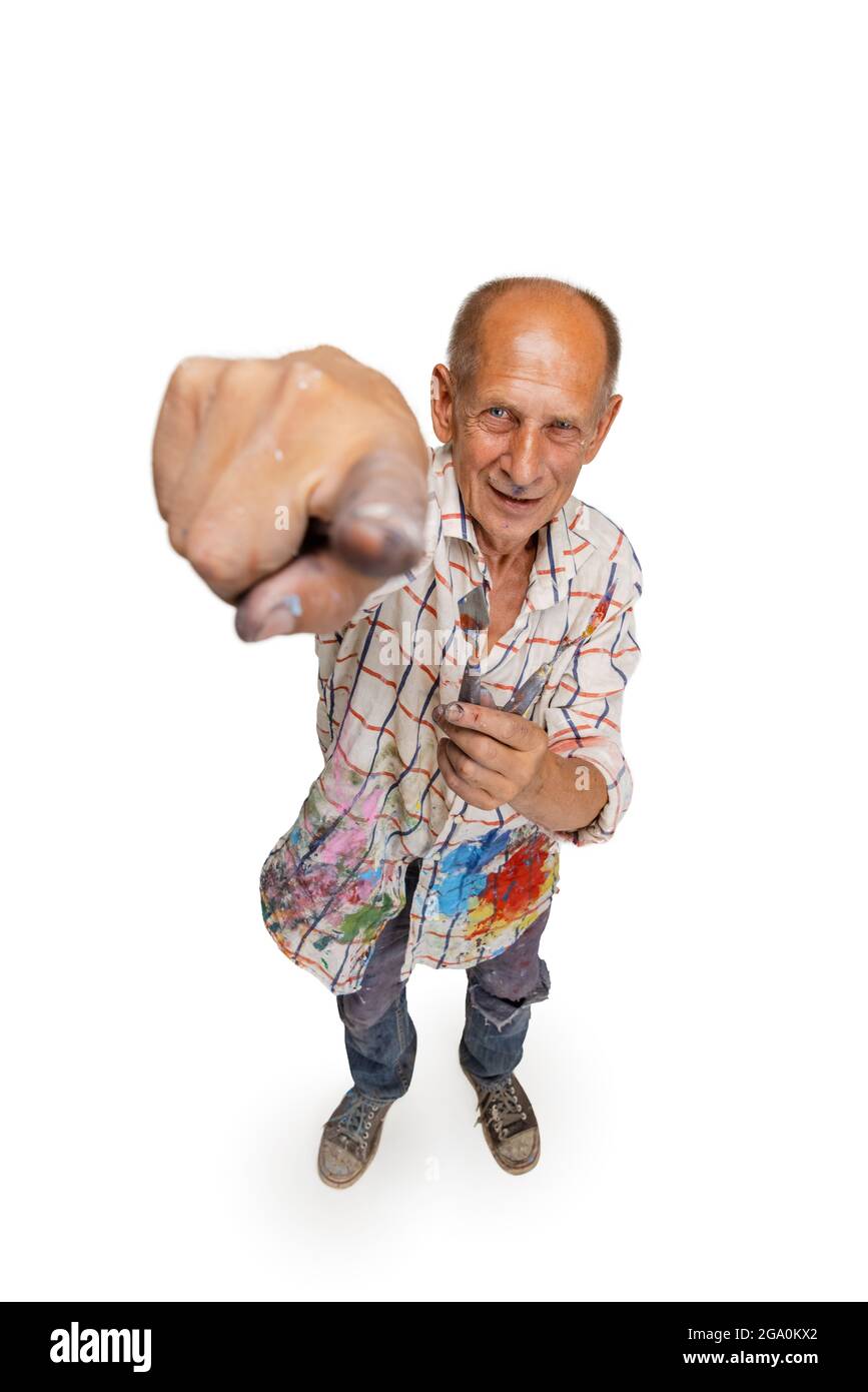 Mature or senior grey painter with a brush standing in front of camera ...