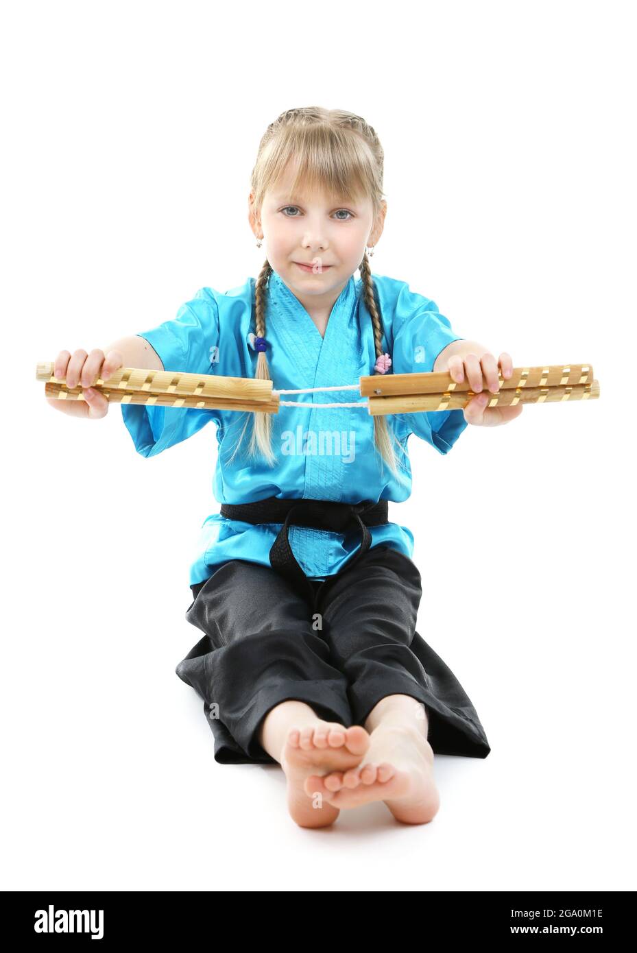 Little girl in kimono doing exercises with nunchaku isolated on white ...