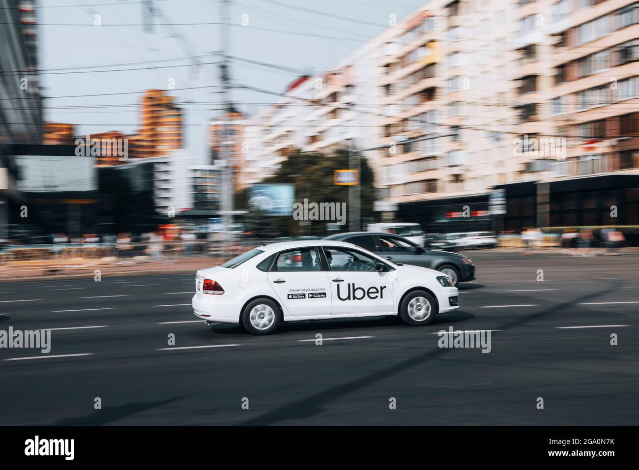Ukraine, Kyiv - 16 July 2021: White Taxi Uber car moving on the street ...