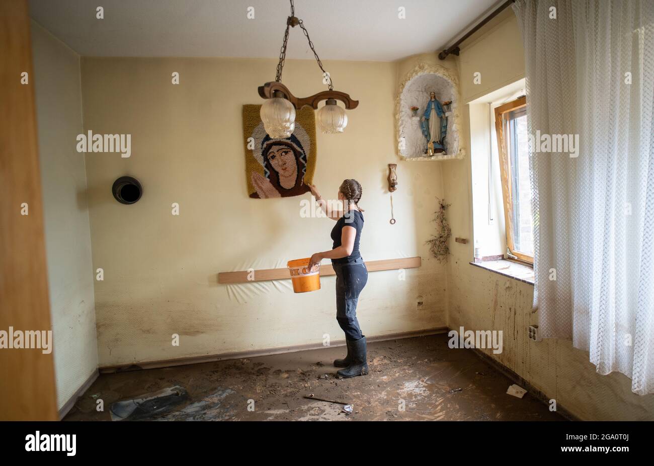 Erftstadt Blessem, Germany. 28th July, 2021. A helper clears a picture ...