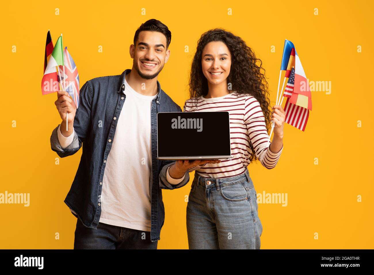Smiling Arab Couple Holding International Flags And Laptop Computer ...