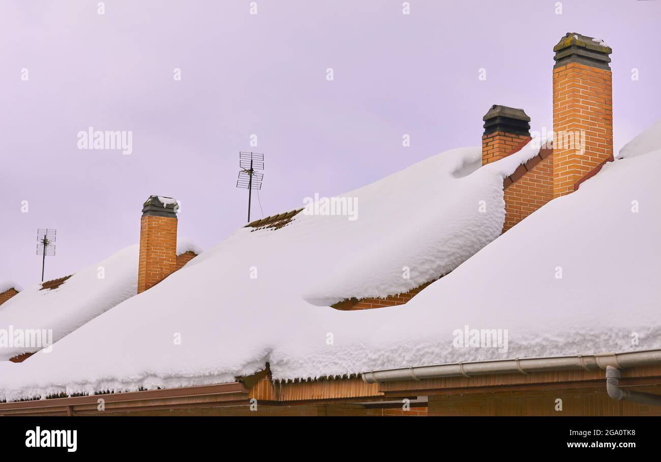 Pitched roofs covered with heavy snow after the Storm Filomena snowfall ...