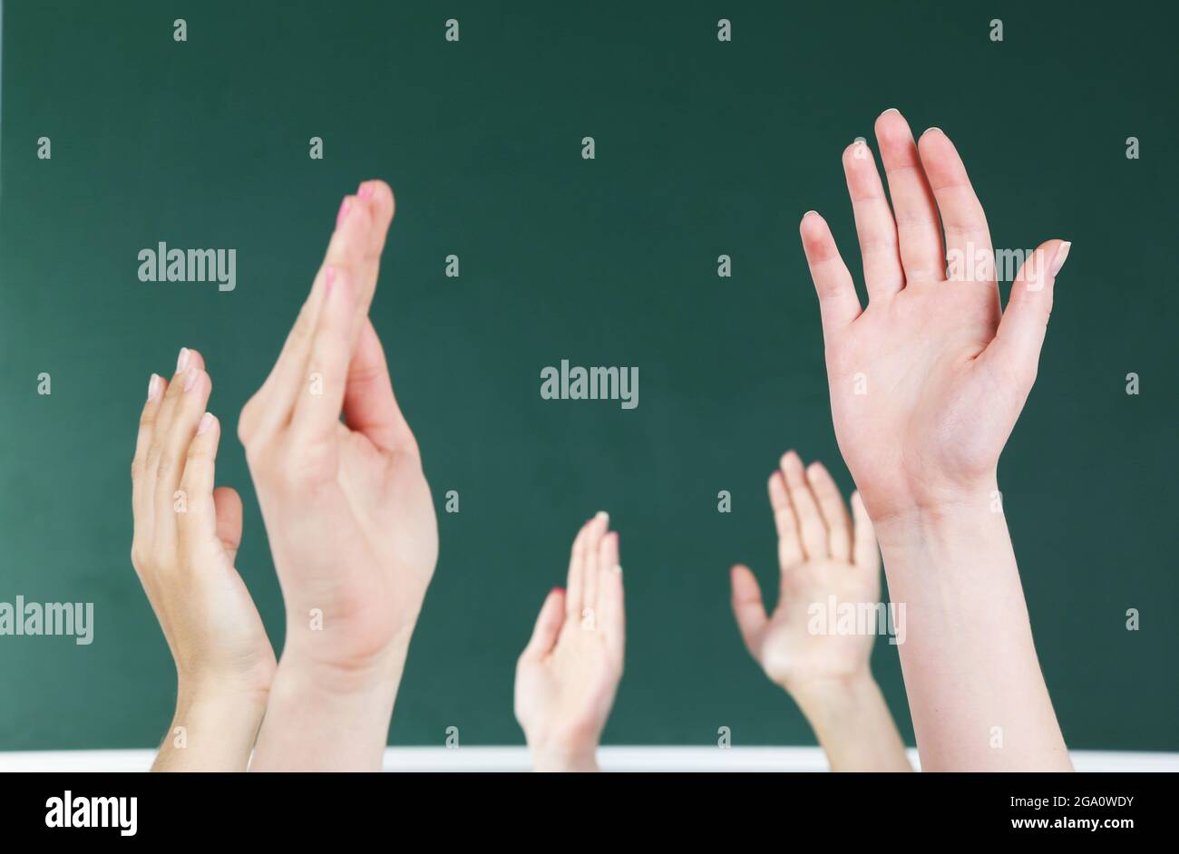 Raised hands on blackboard background in class Stock Photo - Alamy