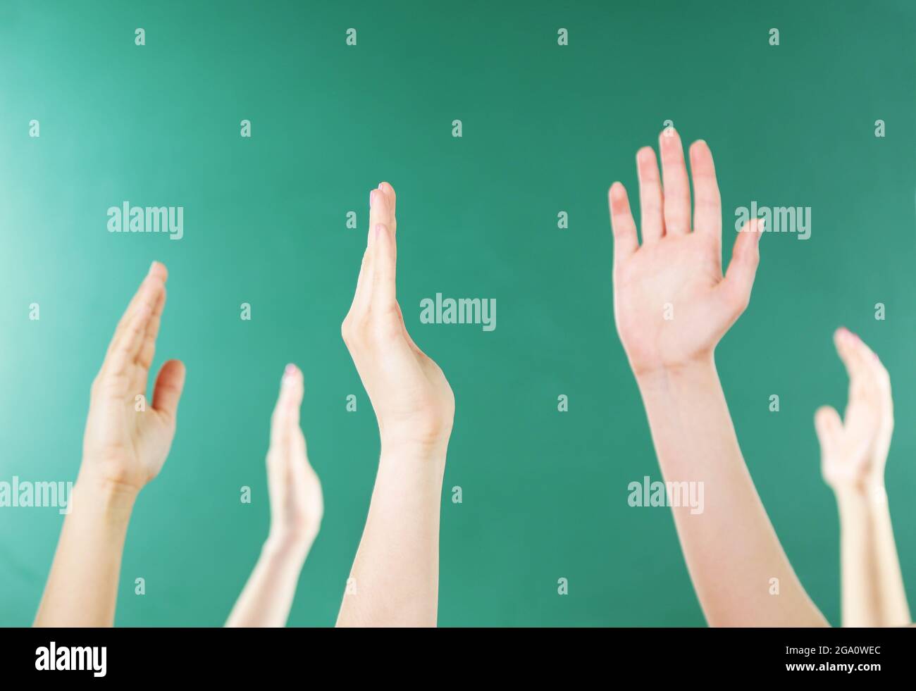 Raised hands on blackboard background in class Stock Photo - Alamy