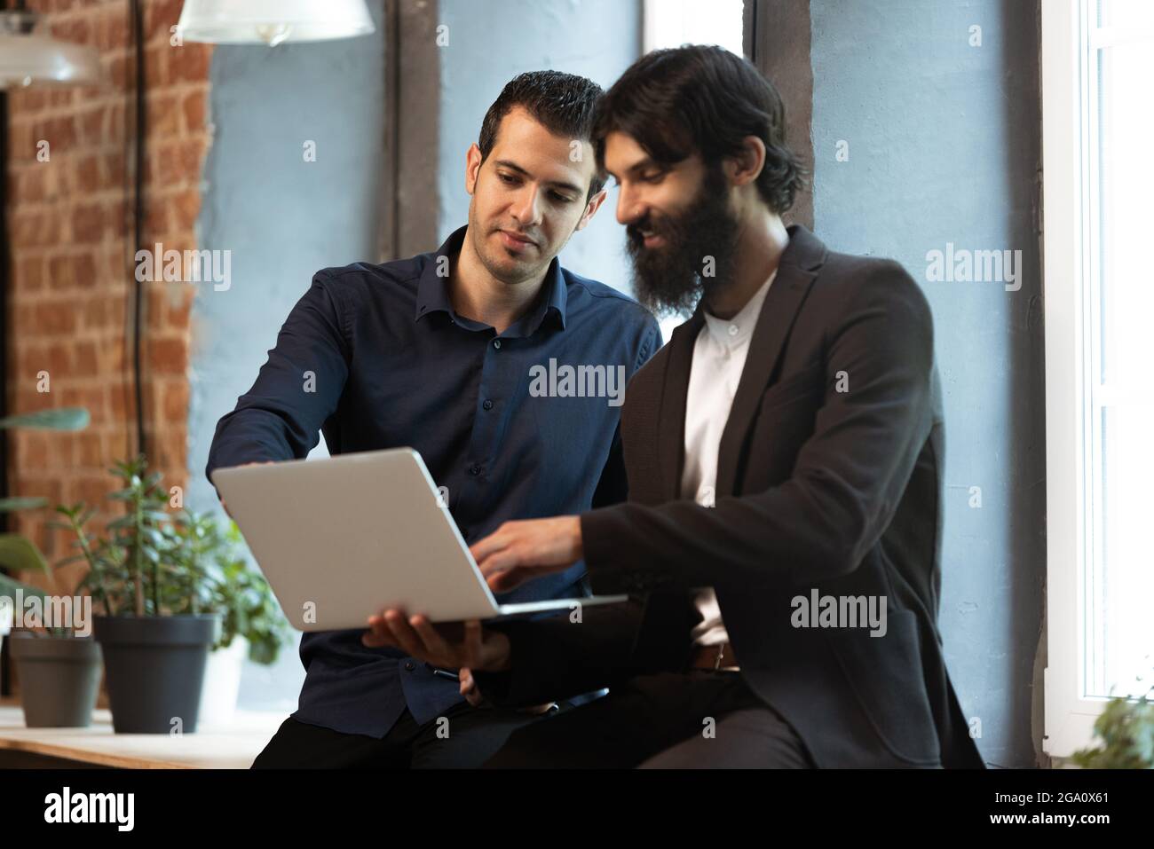 Young men working in modern office using devices and gadgets. Making ...