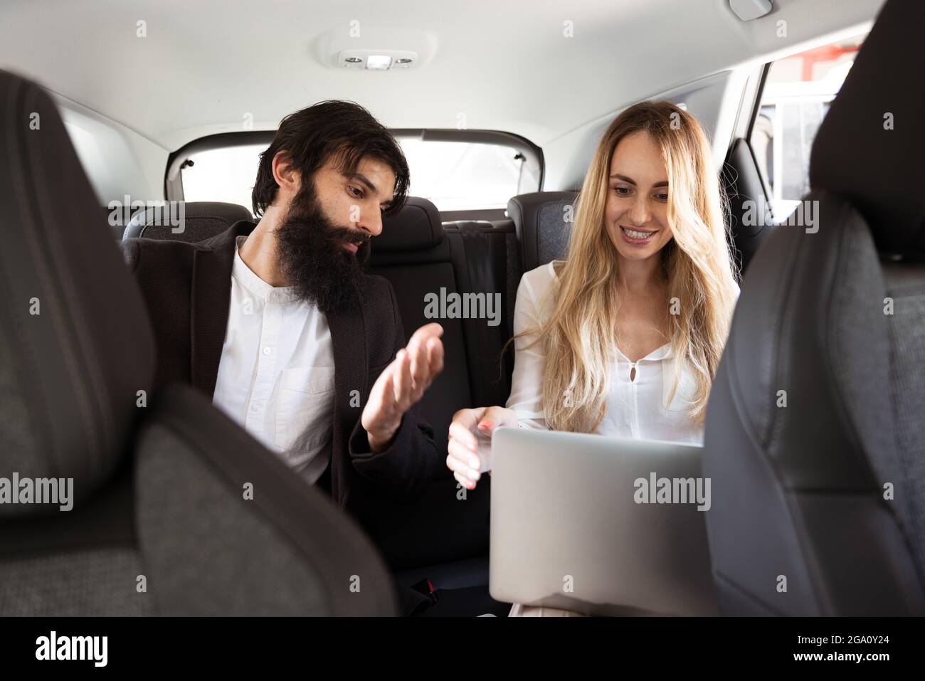 Businessmen working in the drivers seat in car Stock Photo - Alamy