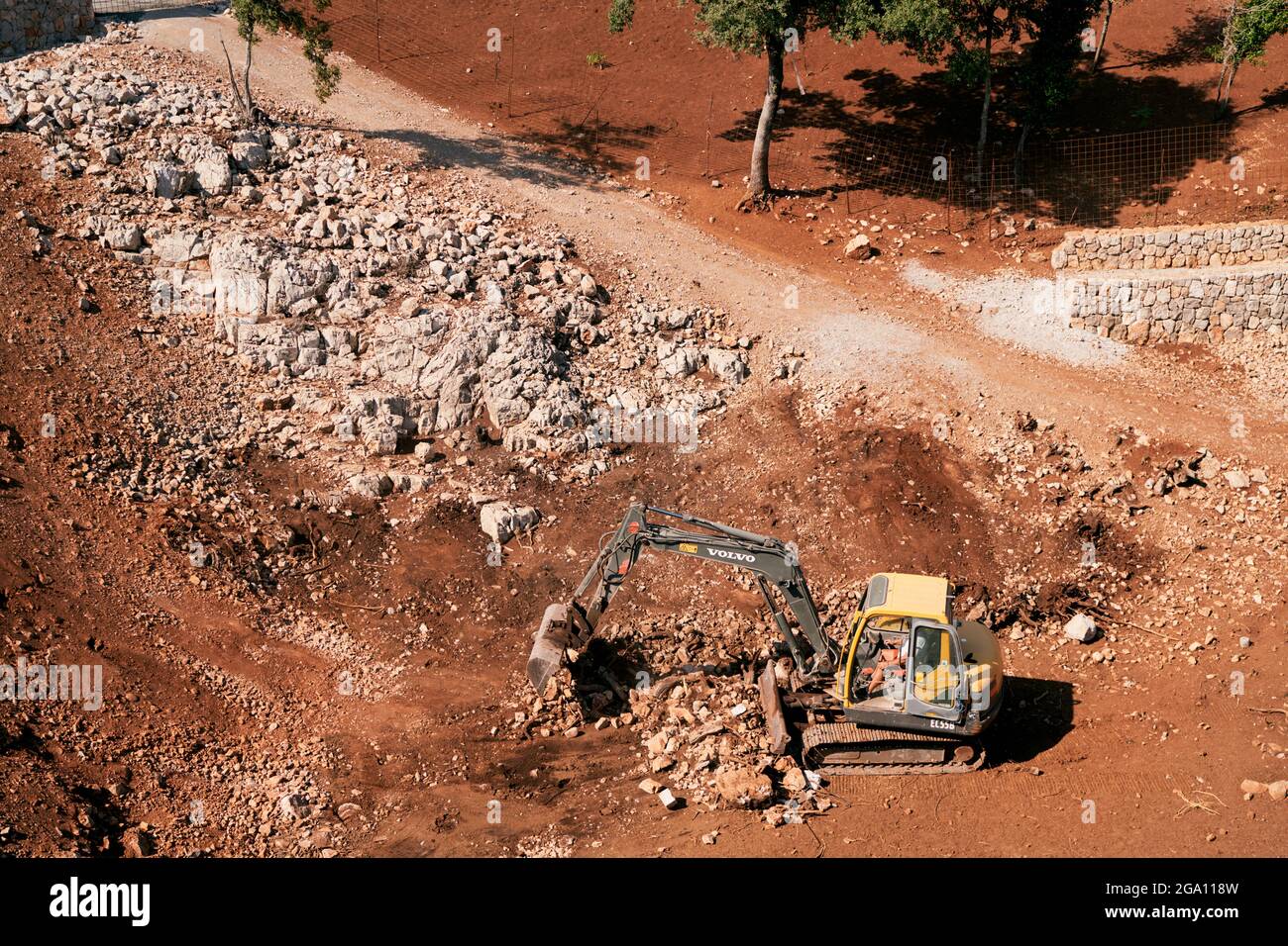 Yellow excavator works in a quarry. View from above Stock Photo - Alamy