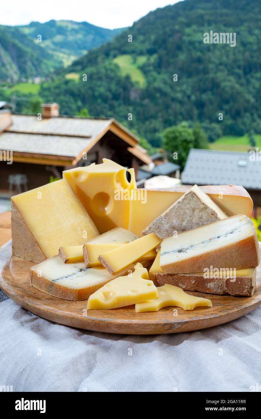 Cheese collection, wooden board with French cheeses comte, beaufort ...