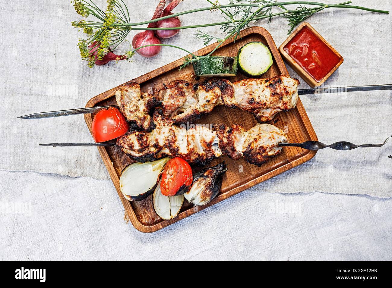 Delicious kebab on skewers. Fried meat on a wooden plate. Grilled meat ...