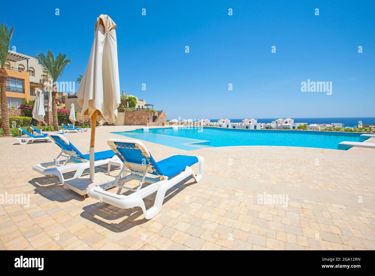 Large outdoor swimming pool at a luxury tropical hotel resort with sun ...