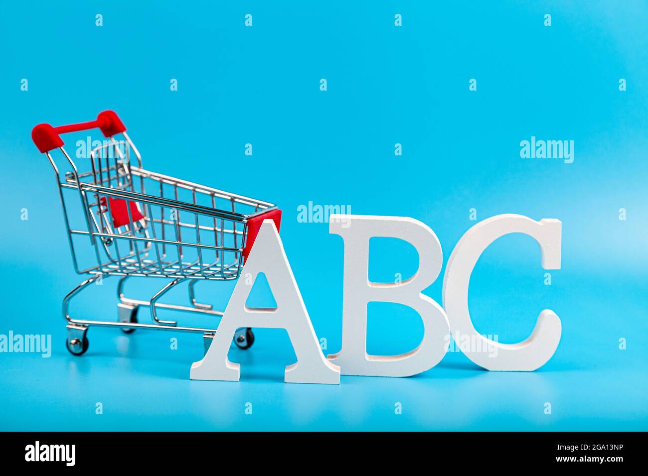 ABC letters and shopping cart on a blue background. Shopping for school ...