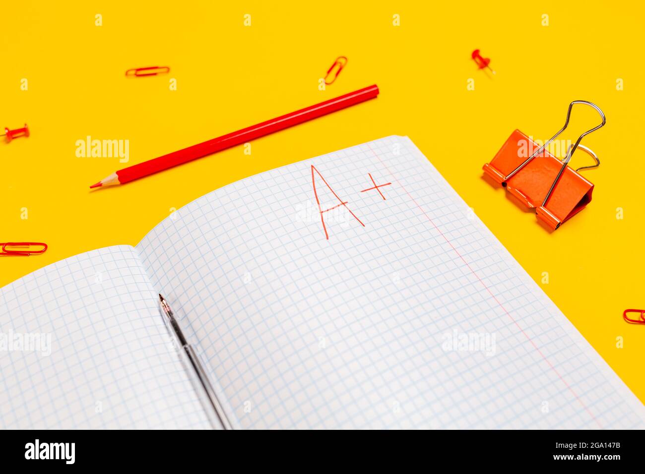 A composition of notebook with an excellent grade on a yellow ...