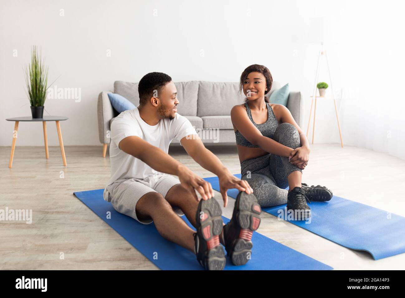 Athletic black couple making exercises on sport mats at home, full ...