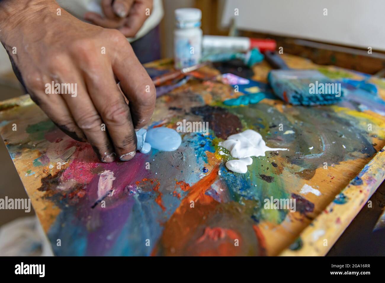 Closeup of hand mixing paint on palette at workshop Stock Photo - Alamy