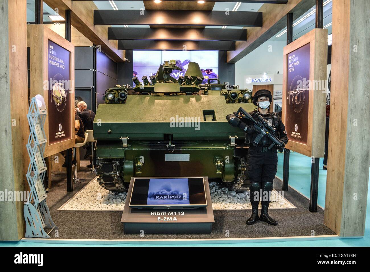 A female gendarmerie stands in front of a mock-up of the M113 Hybrid ...