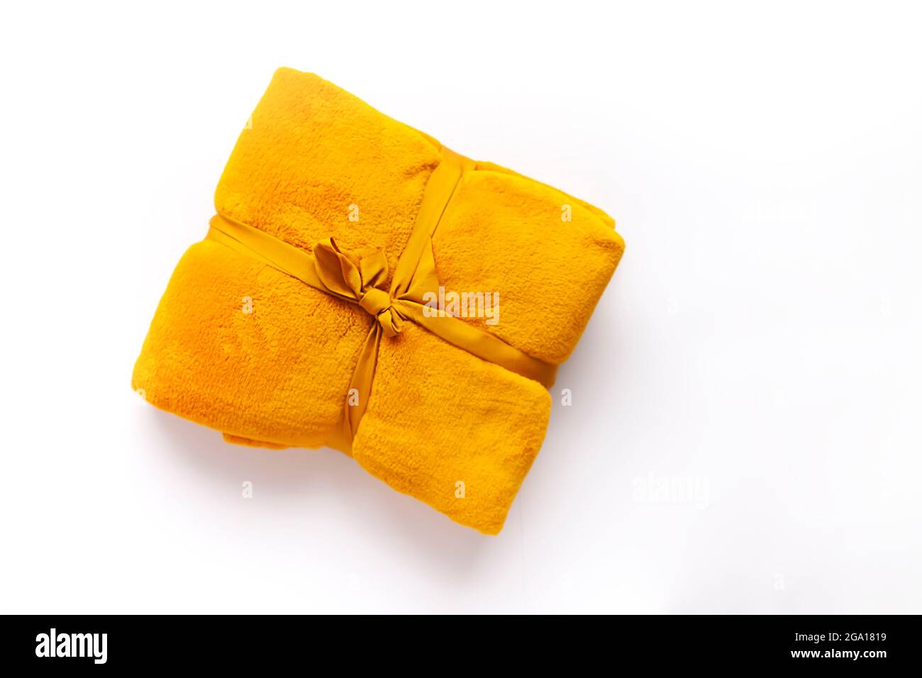 Warm soft yellow plaid tied with a ribbon on white background ...