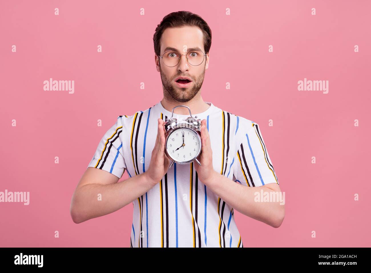 Photo Of Amazed Shocked Young Man Hold Hands Alarm Clock Late Isolated