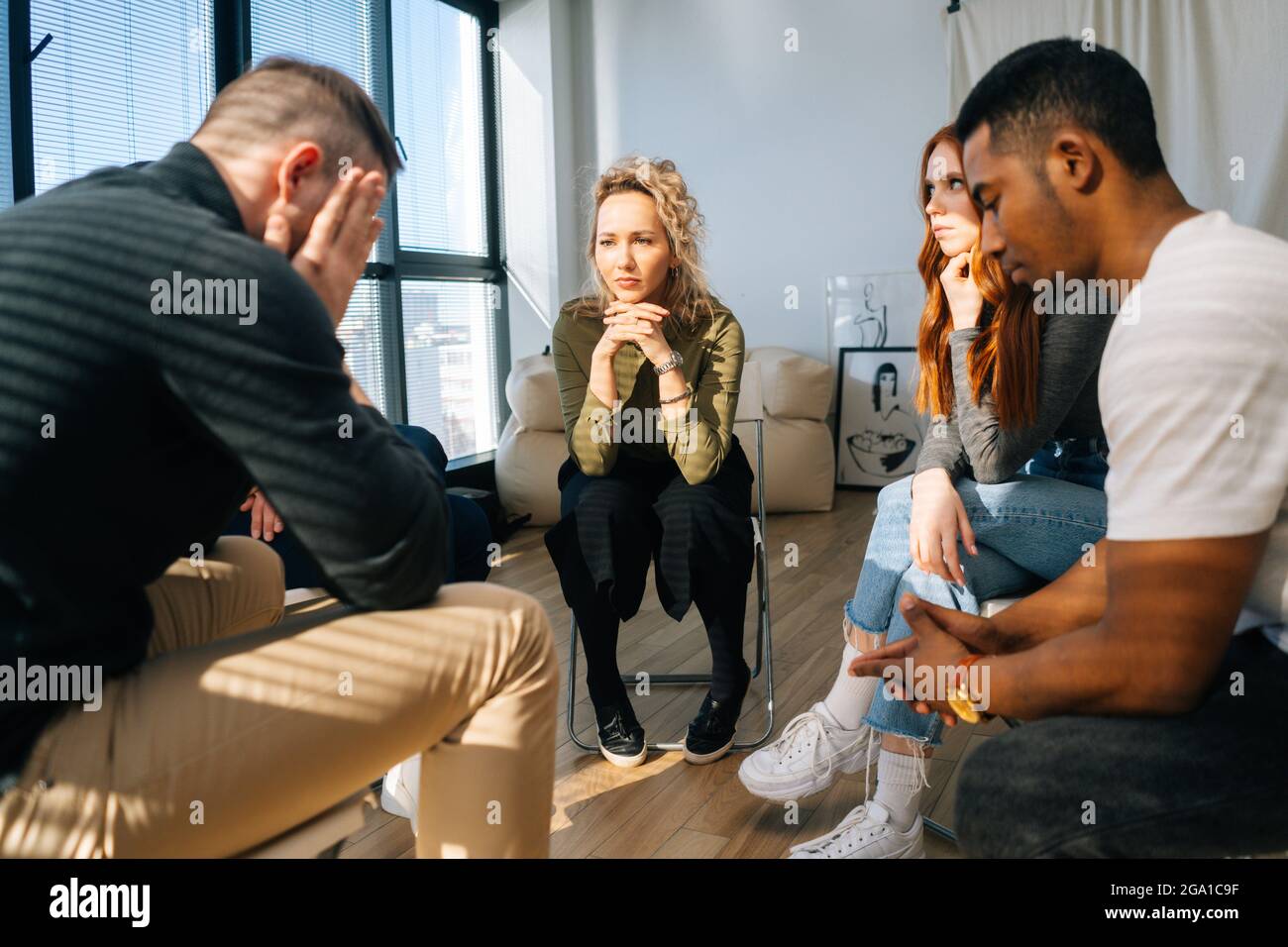 Back view of sad desperate young man telling sad story of mental ...