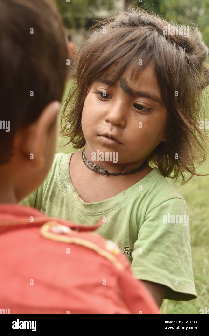 Indian Street Kid, Poor Girl Cleaning cheek of a boy Stock Photo - Alamy