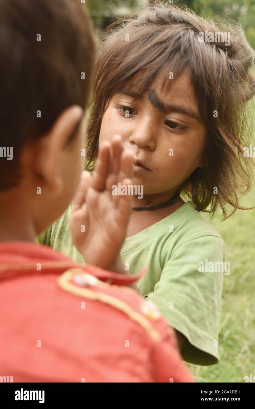 Indian Street Kid, Poor Girl Cleaning cheek of a boy Stock Photo - Alamy