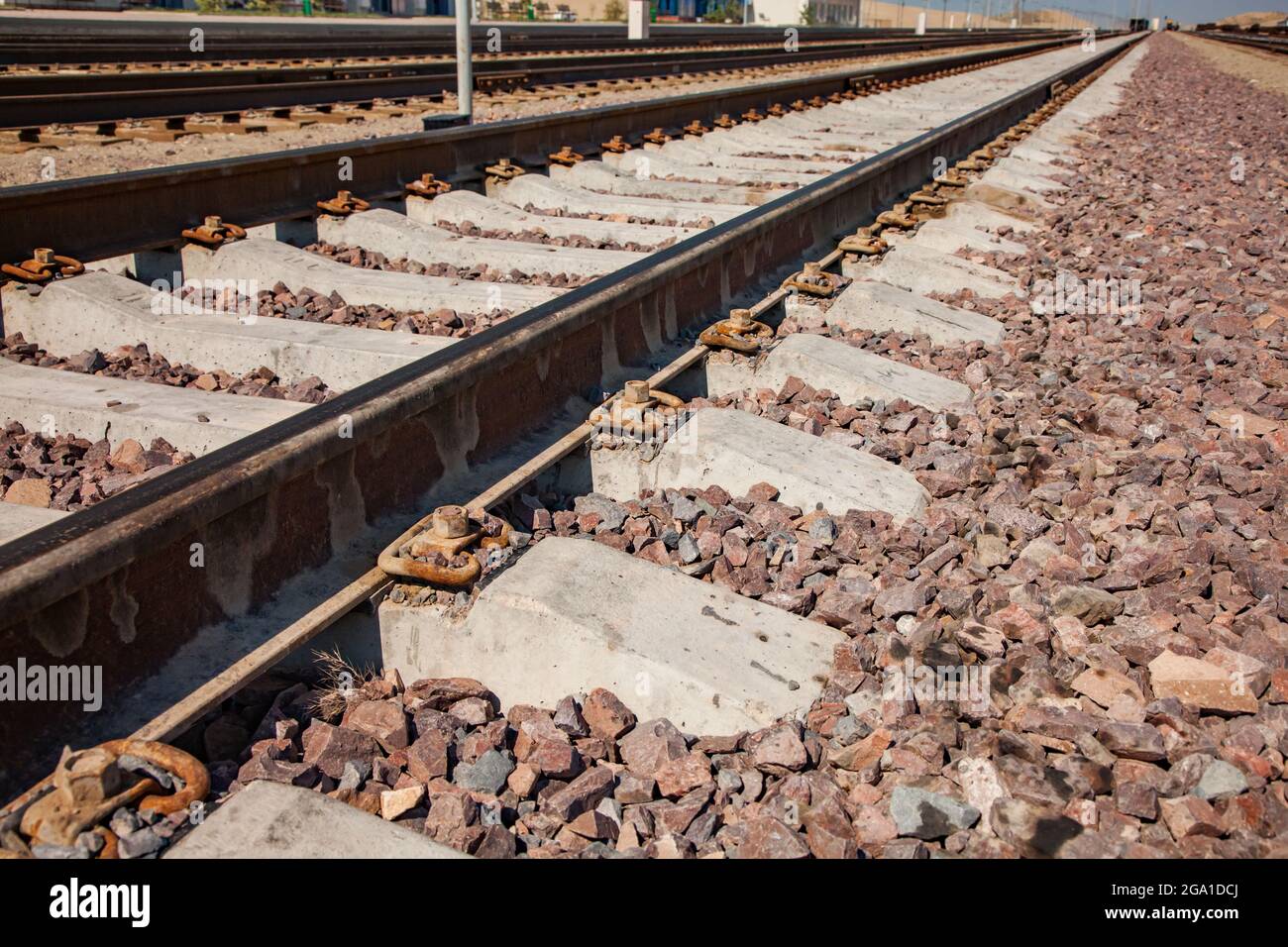 Close-up of rusted steel rails and concrete cross-tie (sleepers). Red ...