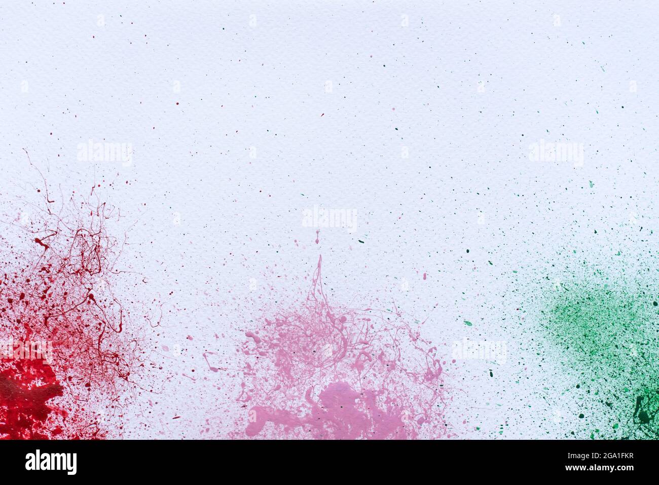 Messy pink, green, and red paint scattered on a white surface with copy ...