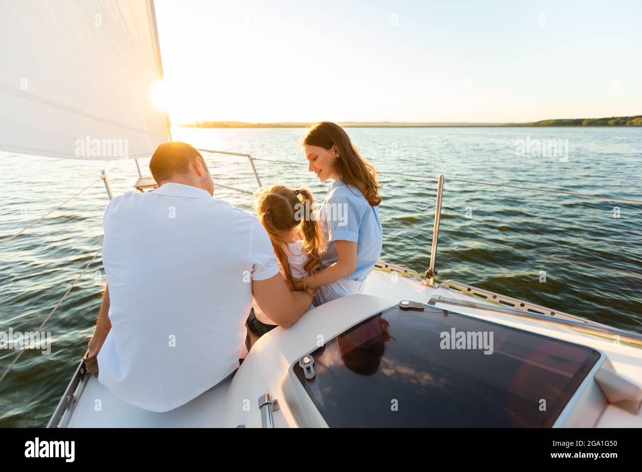 Rear-View Of Family Sailing On Yacht Sitting Together On Deck Stock ...