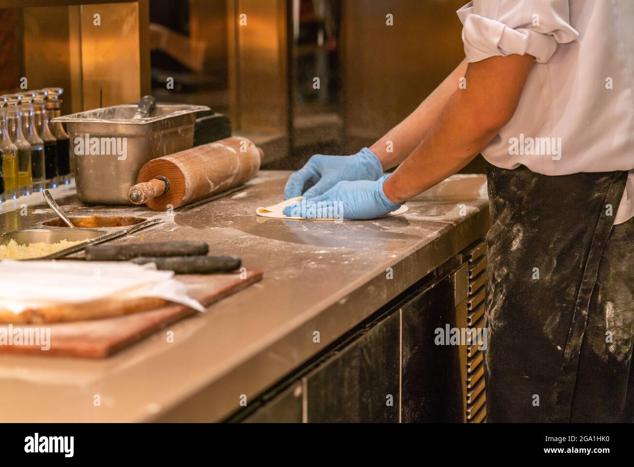 Chef hand making the pizza in kitchen Stock Photo - Alamy