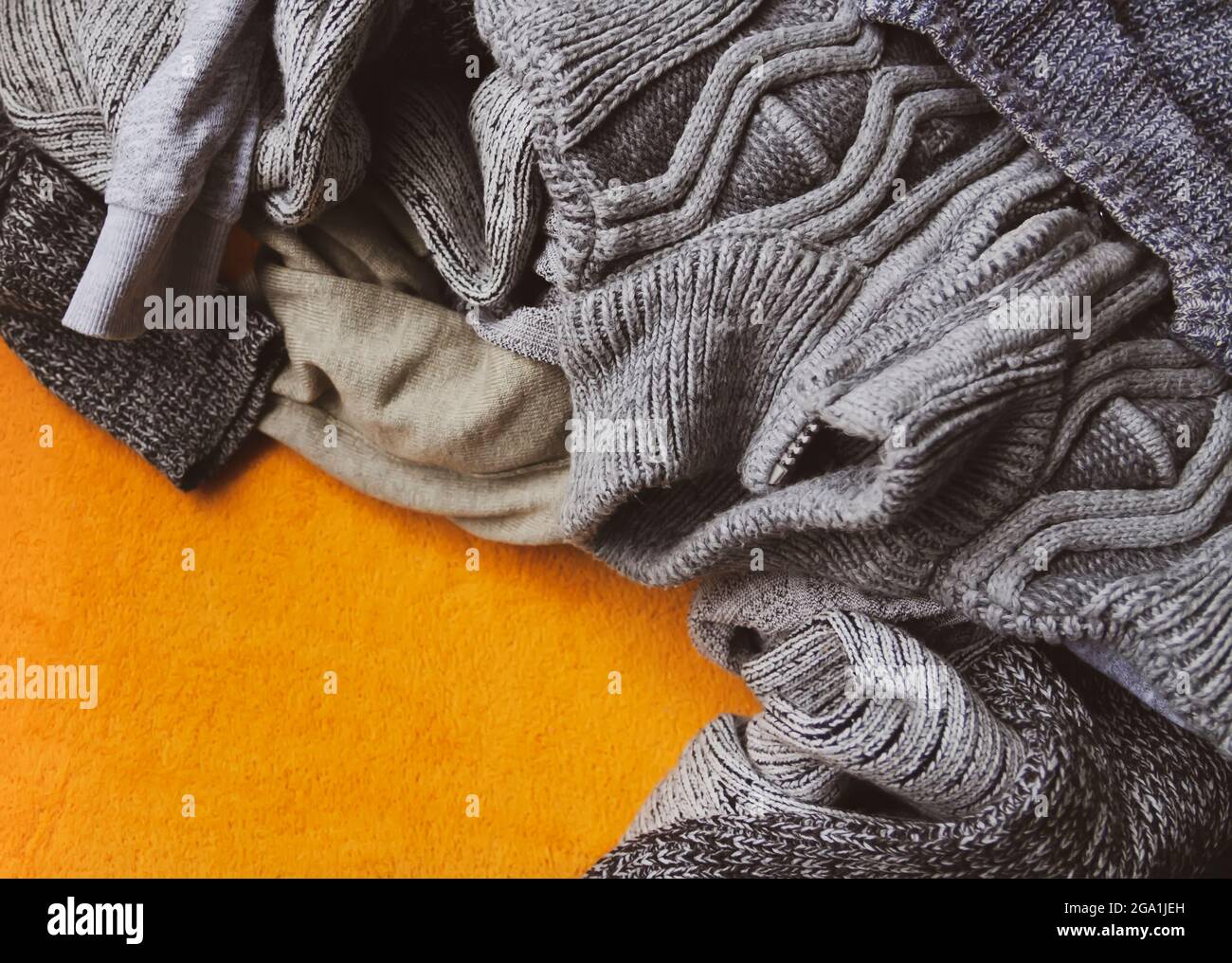 Warm knitted jumpers and sweaters on bright yellow background Stock ...