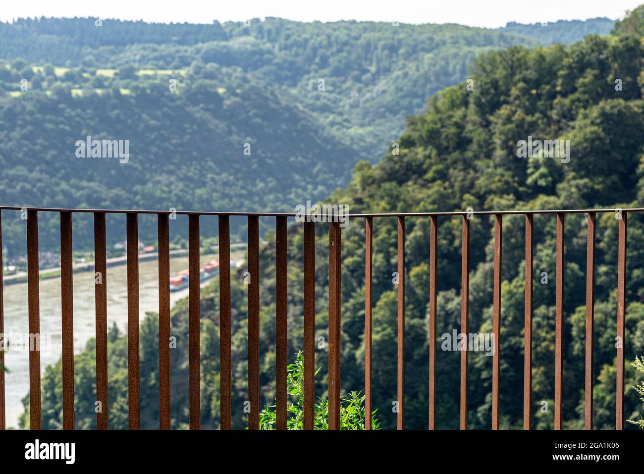 Rusty metal fence at the edge of the river valley, visible trees on the ...