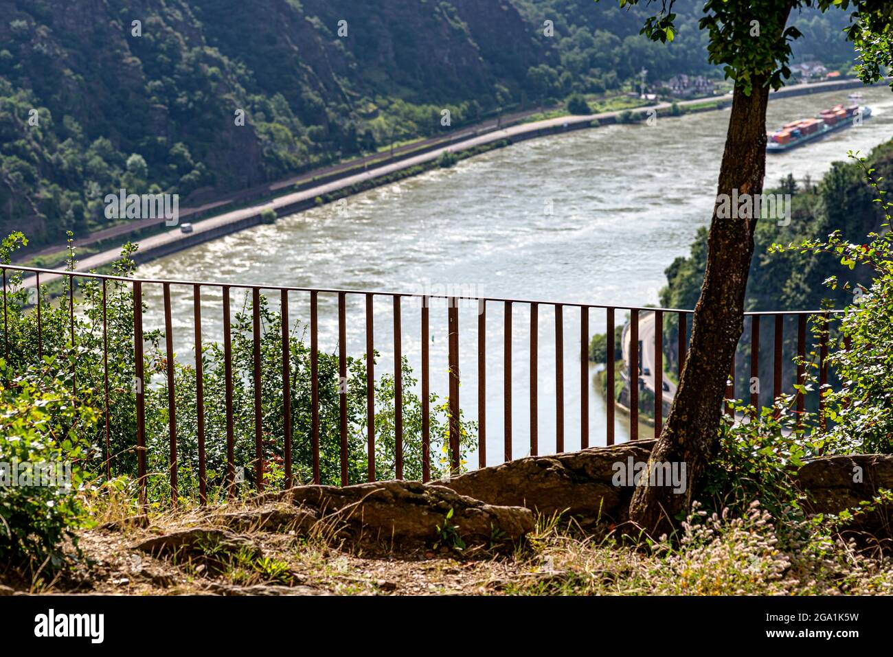 Rusty metal fence at the edge of the river valley, visible trees on the ...