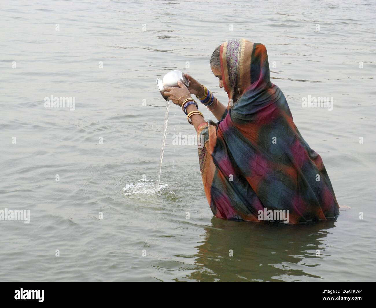 Varanasi, India. One woman performing morning pray ritual in the holy ...