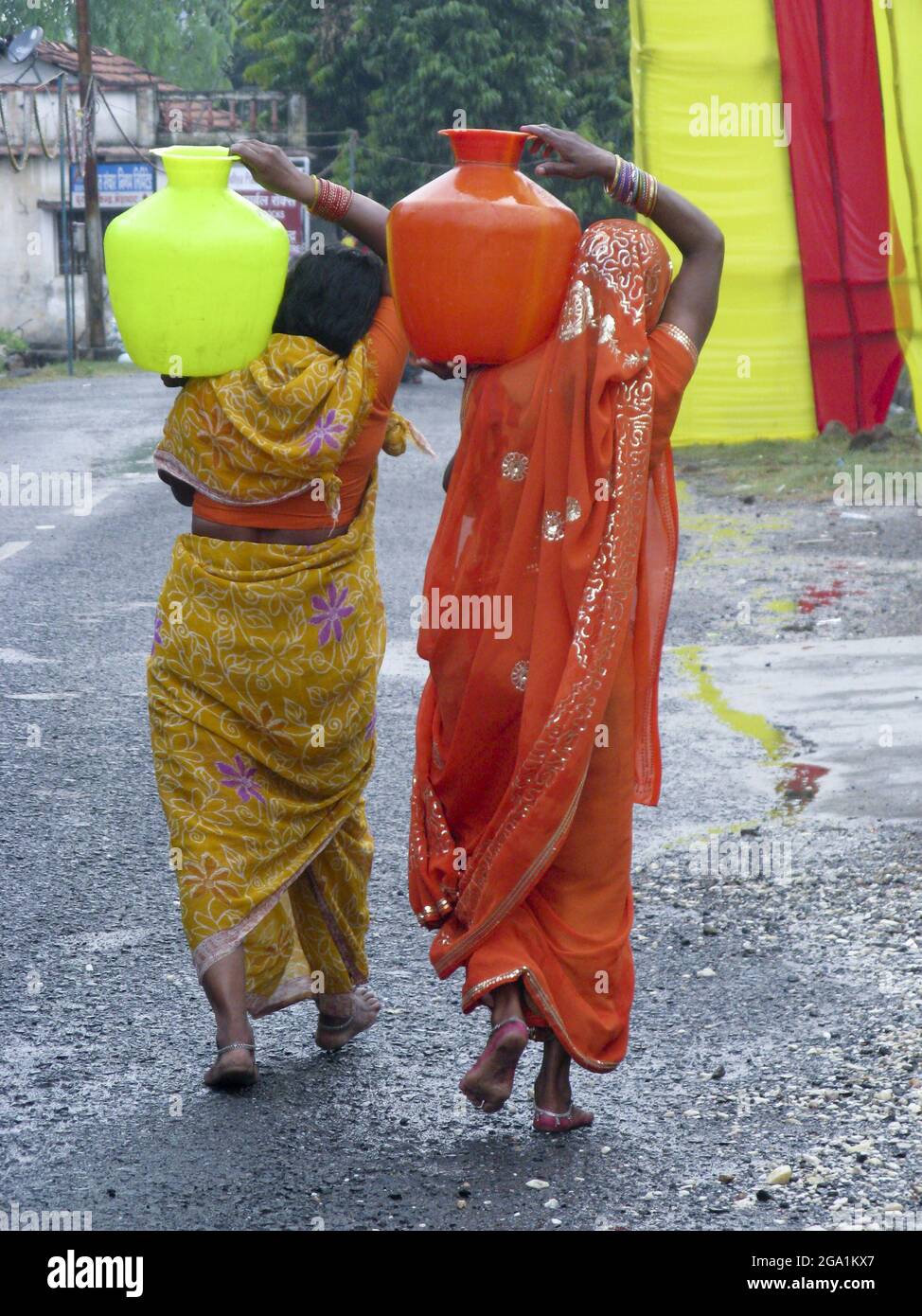 Pachmarhi, India. Two Indian women carrying big colourful buckets of ...