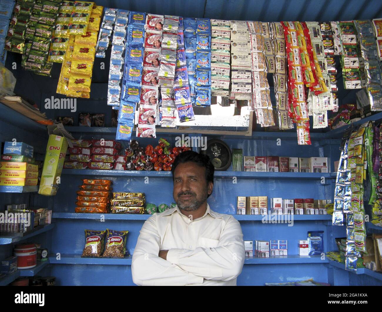 Varanasi, India. Shop owner standing in his tine road side shop in the ...